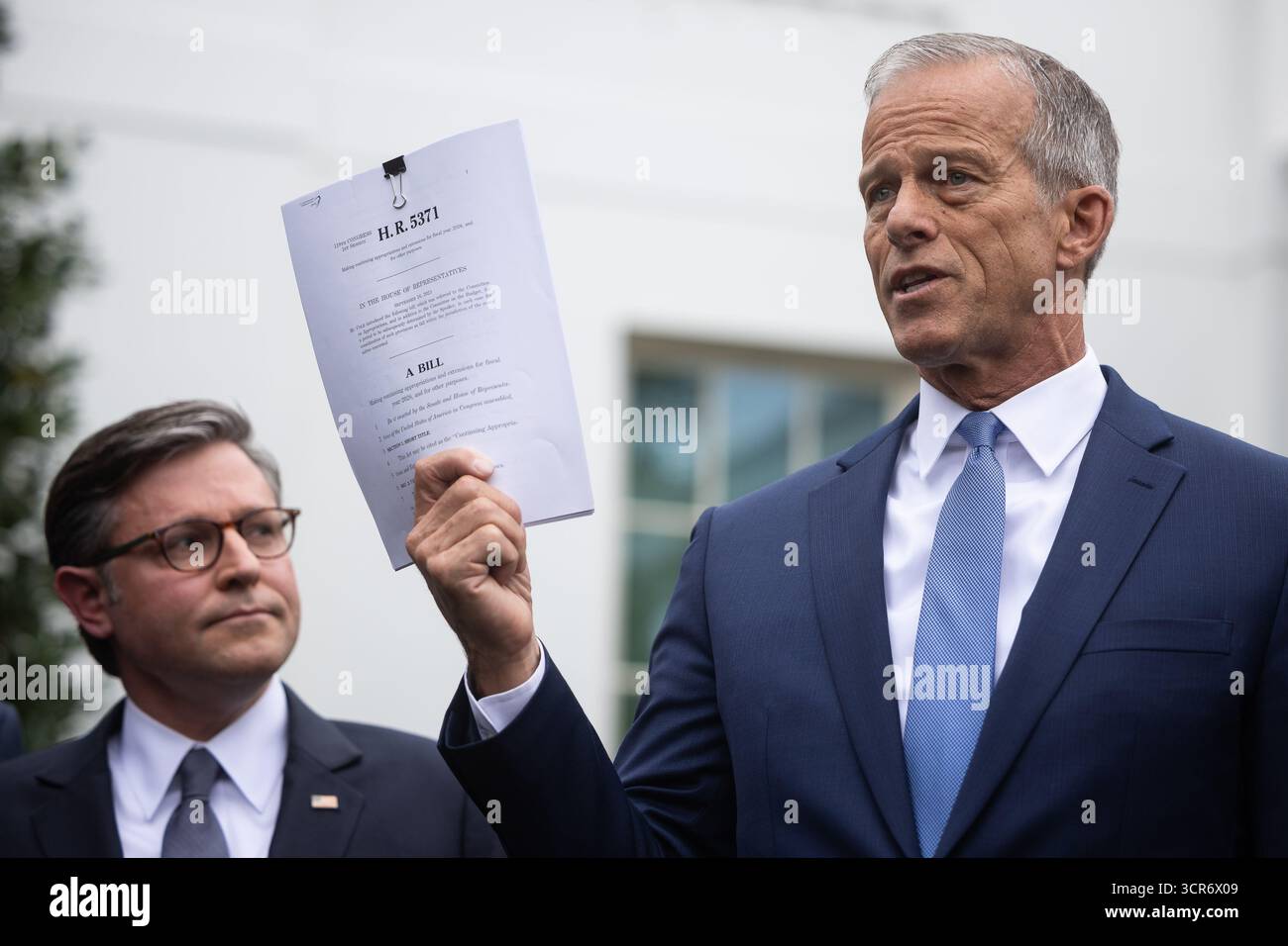 Senate Majority Leader John Thune (R-S.D.) holds a copy of a continuing ...