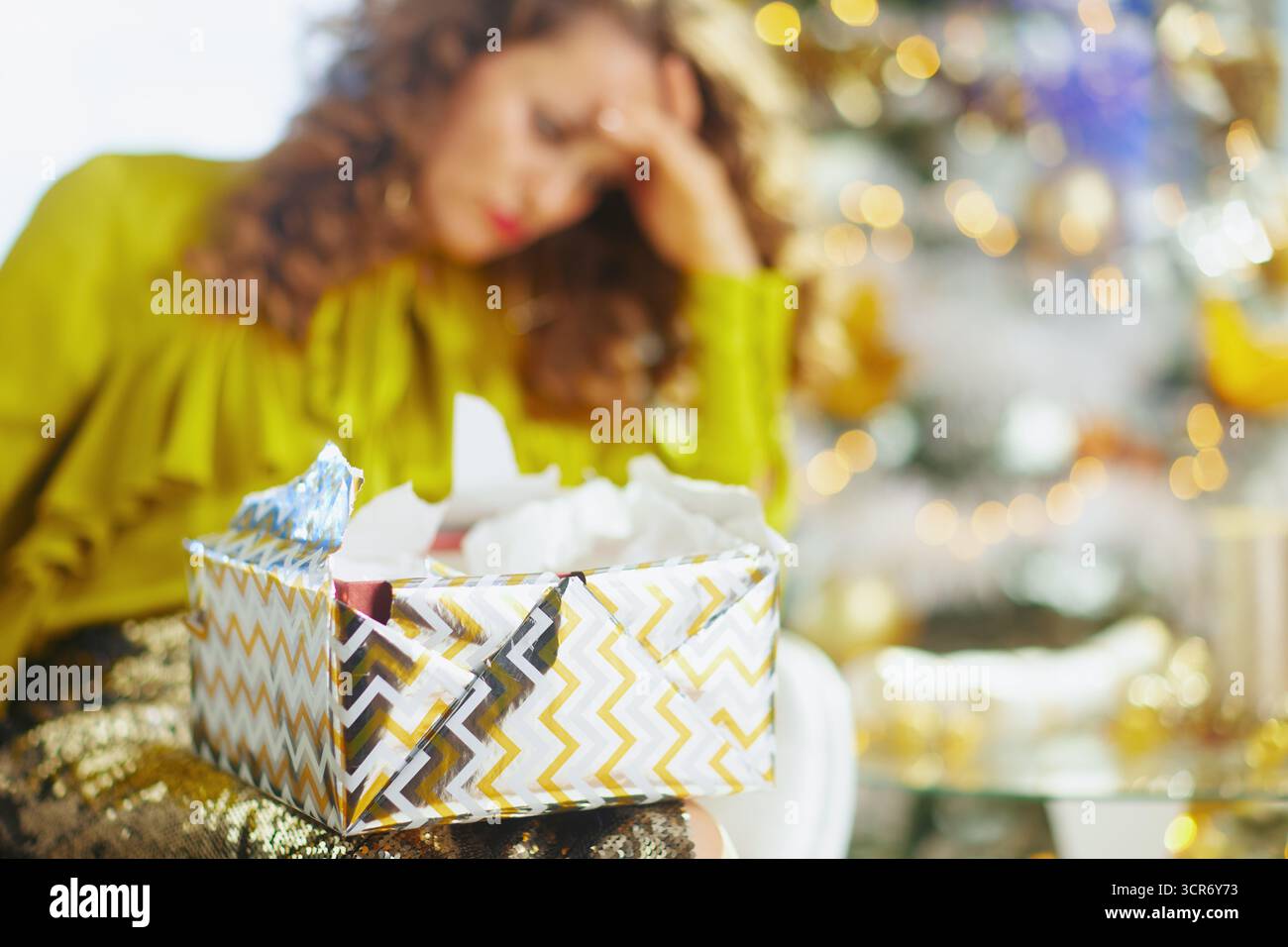 Overwhelmed woman with curly brown hair presses hand to forehead ...