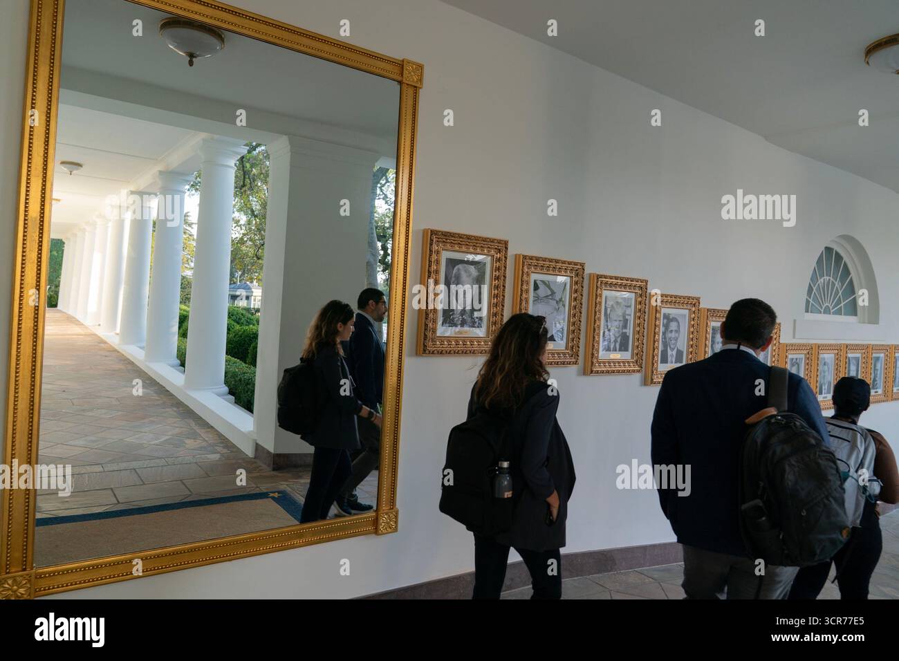 Members of the media walk past a newly installed large mirror at one ...