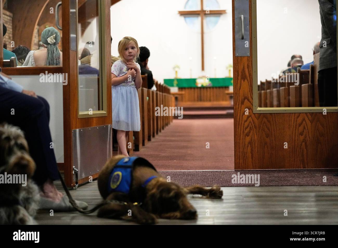 A child looks out from the pew during a service for the Sunday morning ...