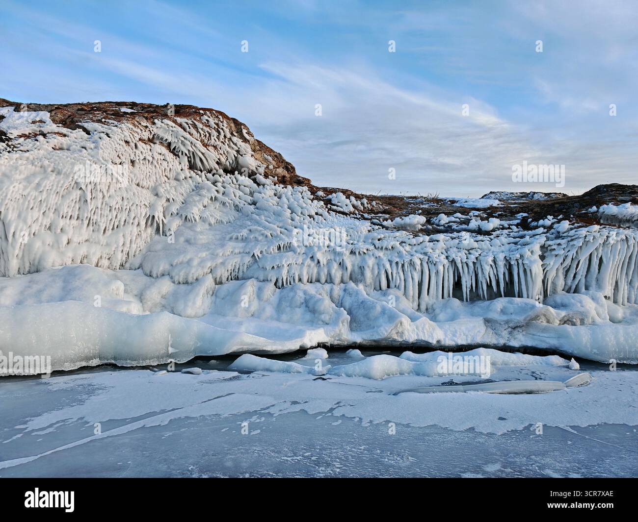 Lake Baikal is covered with ice and snow, thick clear blue ice. Icicles ...