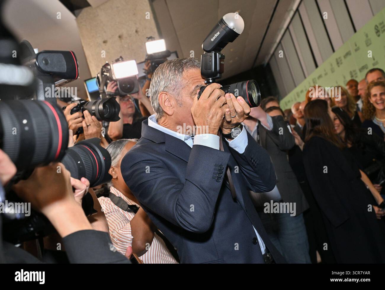 George Clooney borrows a photographers camera at the premiere of "Jay ...