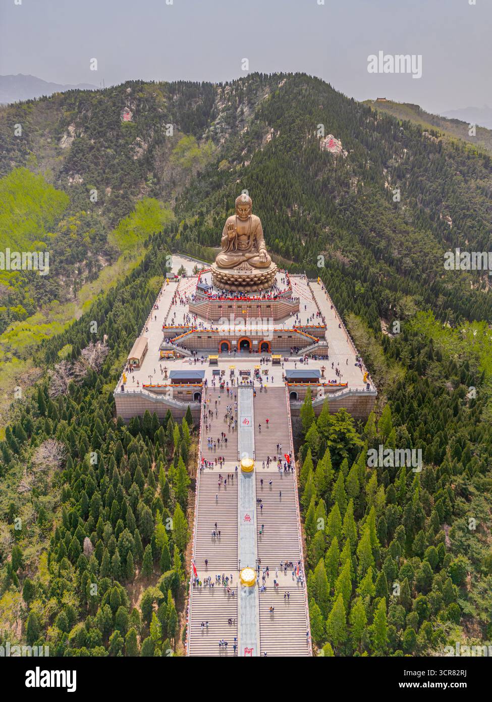Nanshan great Buddha, in China. People climbing the stairway to reach ...