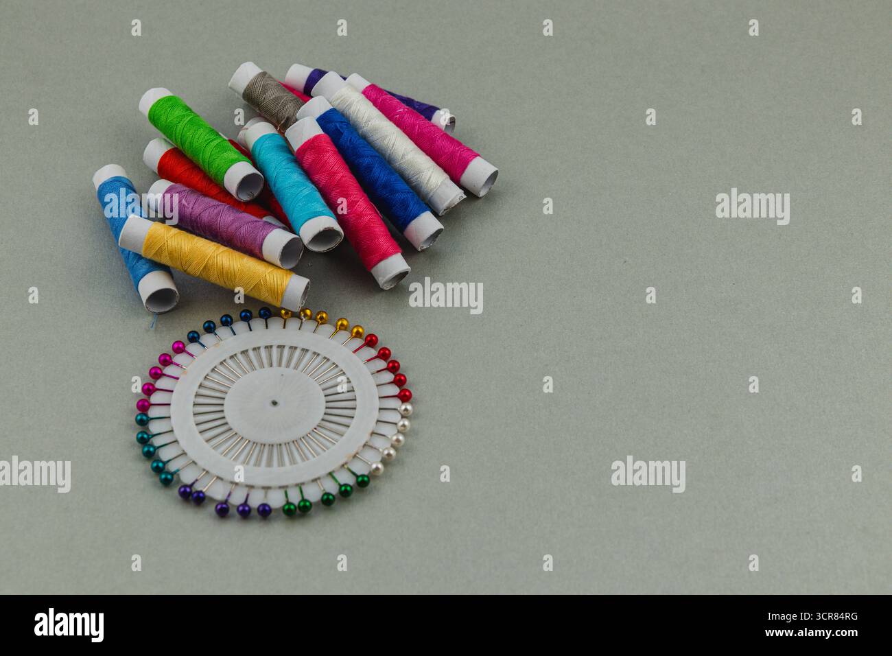 Brightly colored spools of thread are arranged alongside a circular ...