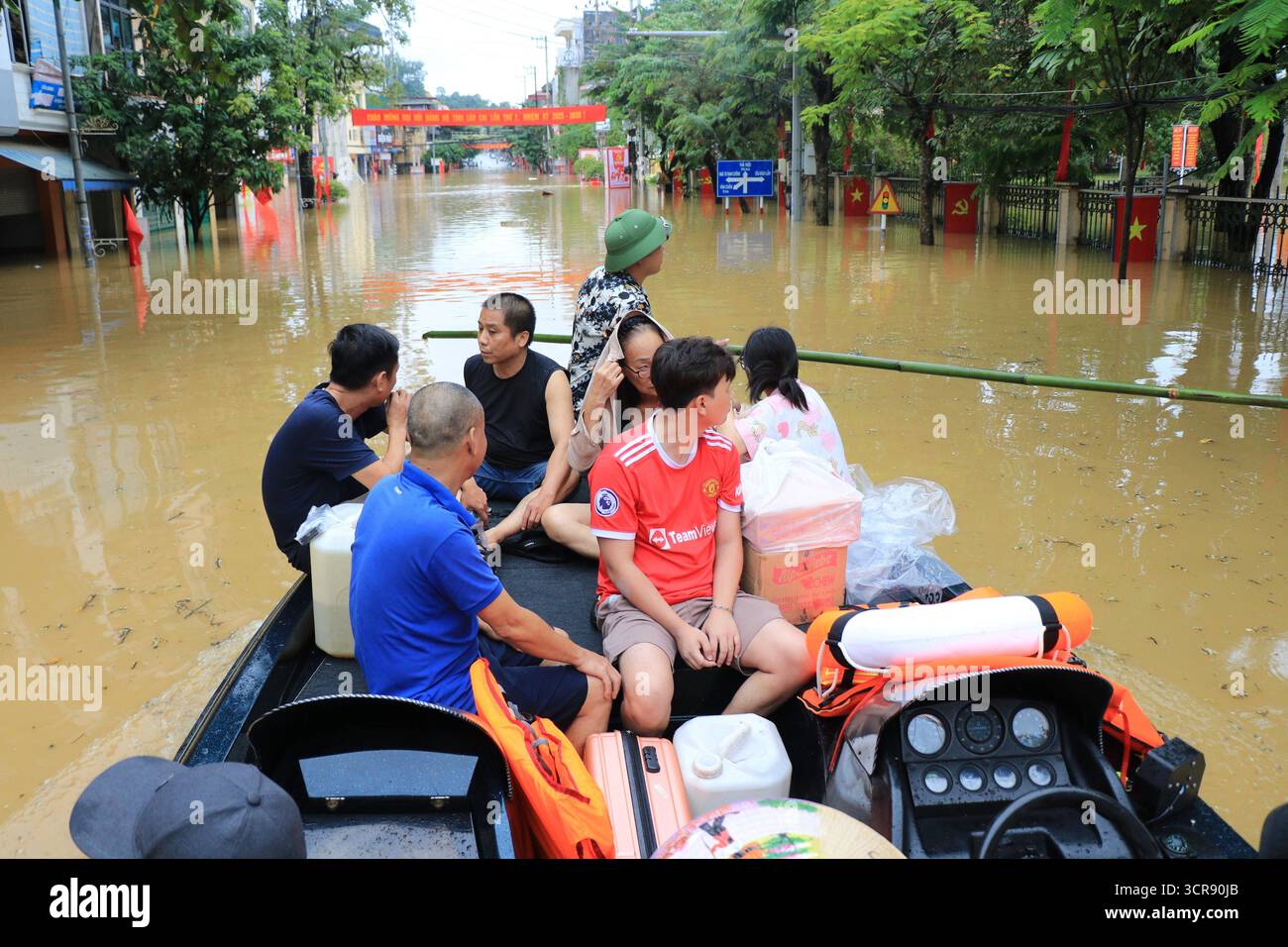 People move by a boat in a flooded street caused by rain following ...
