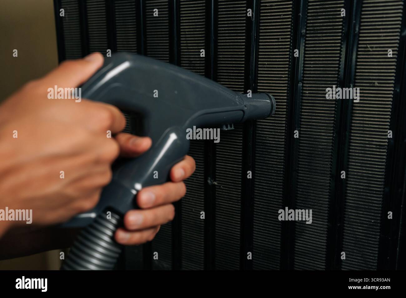 Man using vacuum cleaner attachment to remove dust and debris from ...