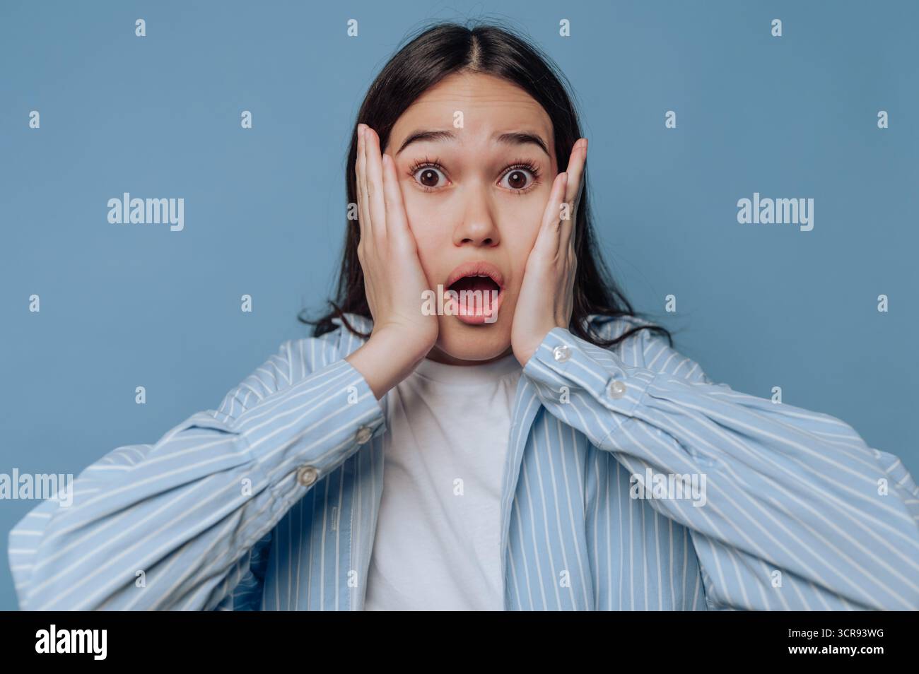 young woman, eyes wide open and mouth opened, expresses sheer ...