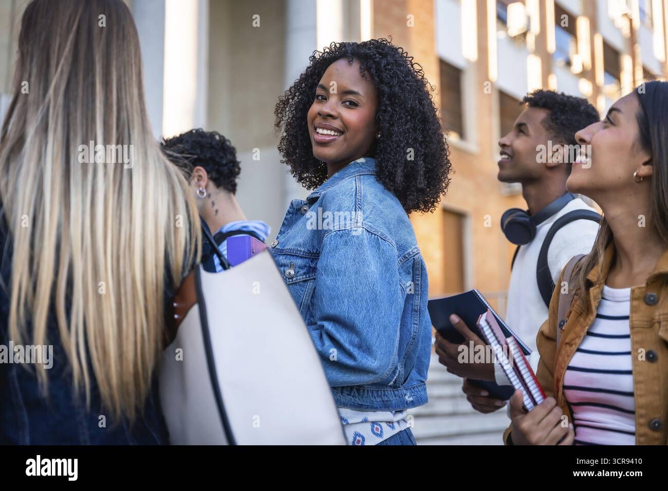 Group of multi ethnic university students walking together on campus ...