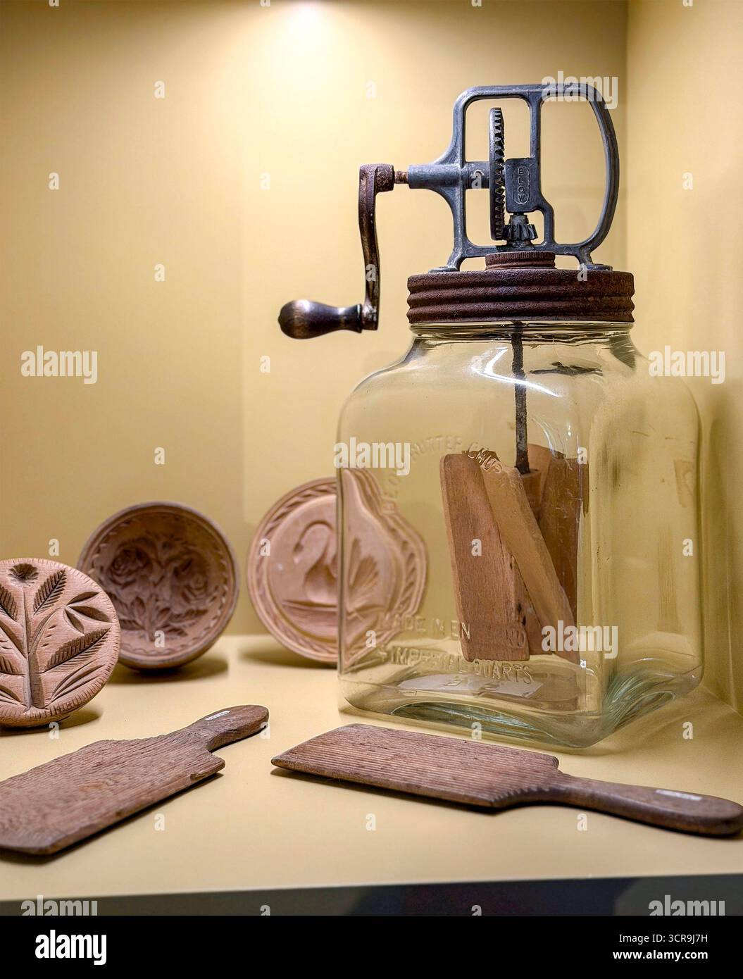 Vintage butter churn with wooden paddles surrounded by traditional ...