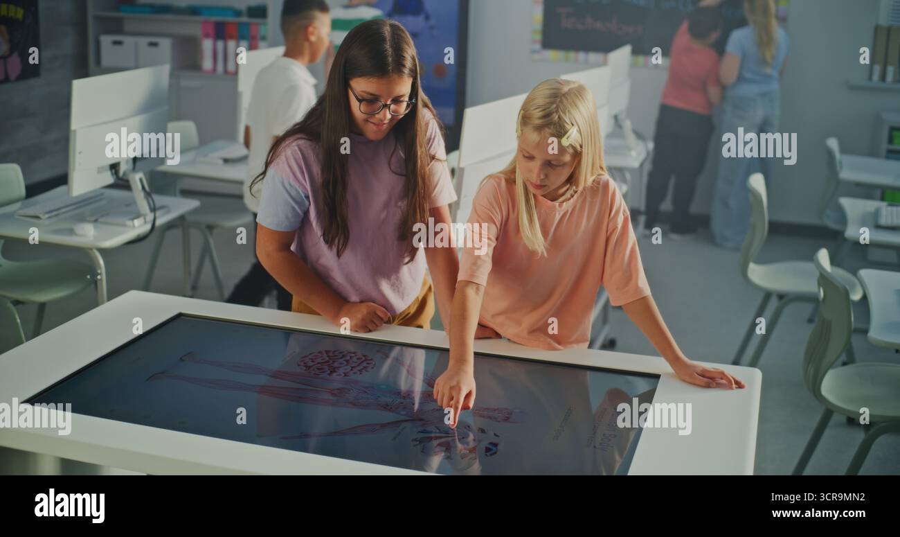Two Schoolgirls Use Large Interactive Touchscreen Table in Bright ...