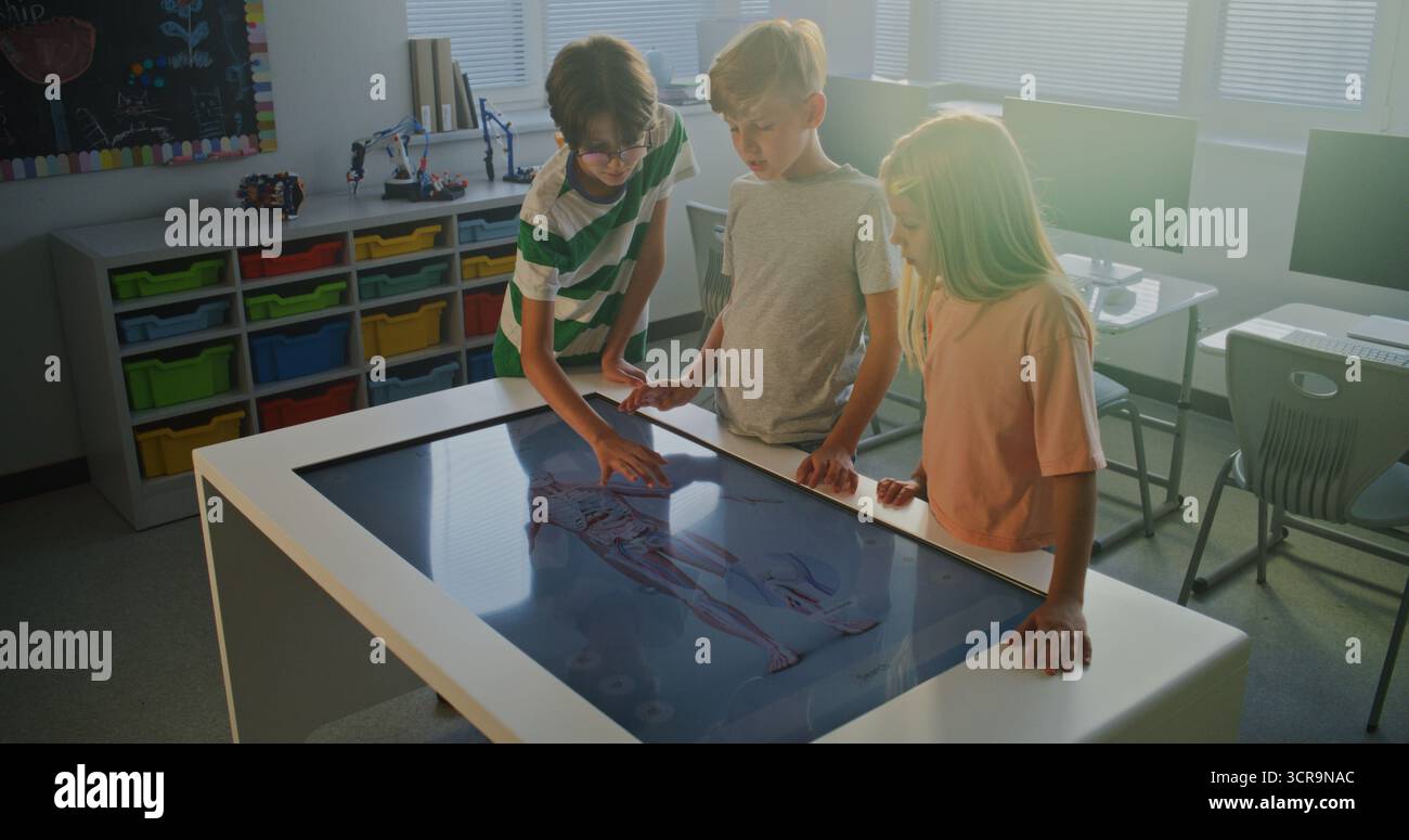 Group of Students Gathered Around Interactive Digital Table With 3D ...