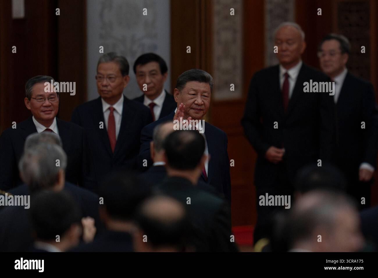 Chinese President Xi Jinping waves as he leads other politburo members ...