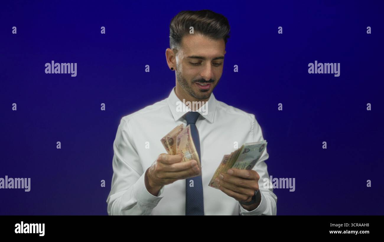 Smiling man in crisp white shirt and tie counting uae dirham banknotes ...
