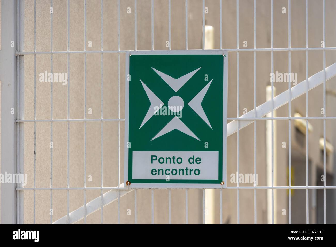 Green assembly point sign indicating safe gathering location during ...