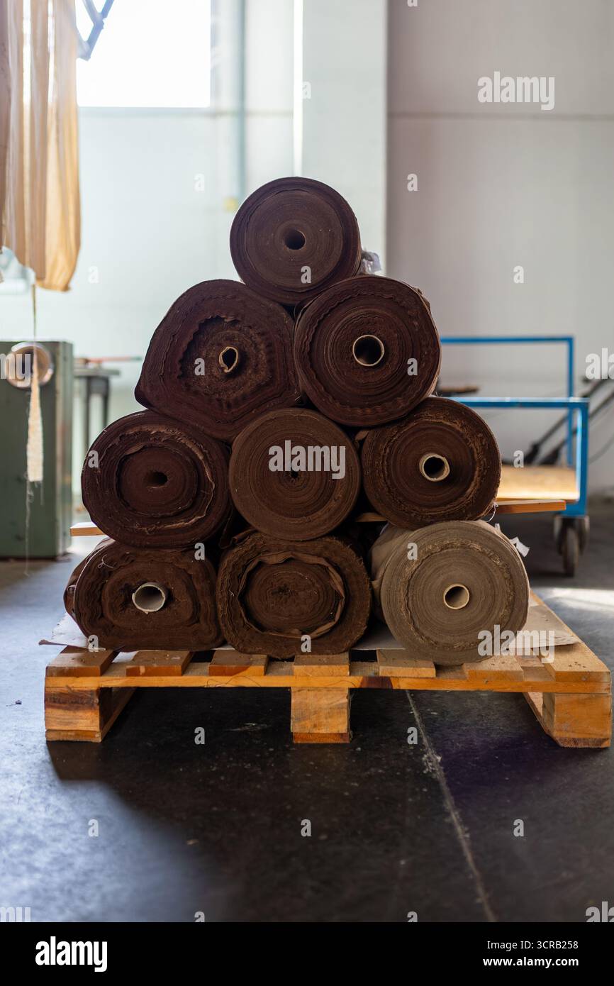 Textile/screen printing warehouse. Fabric rolls on pallet, screen ...