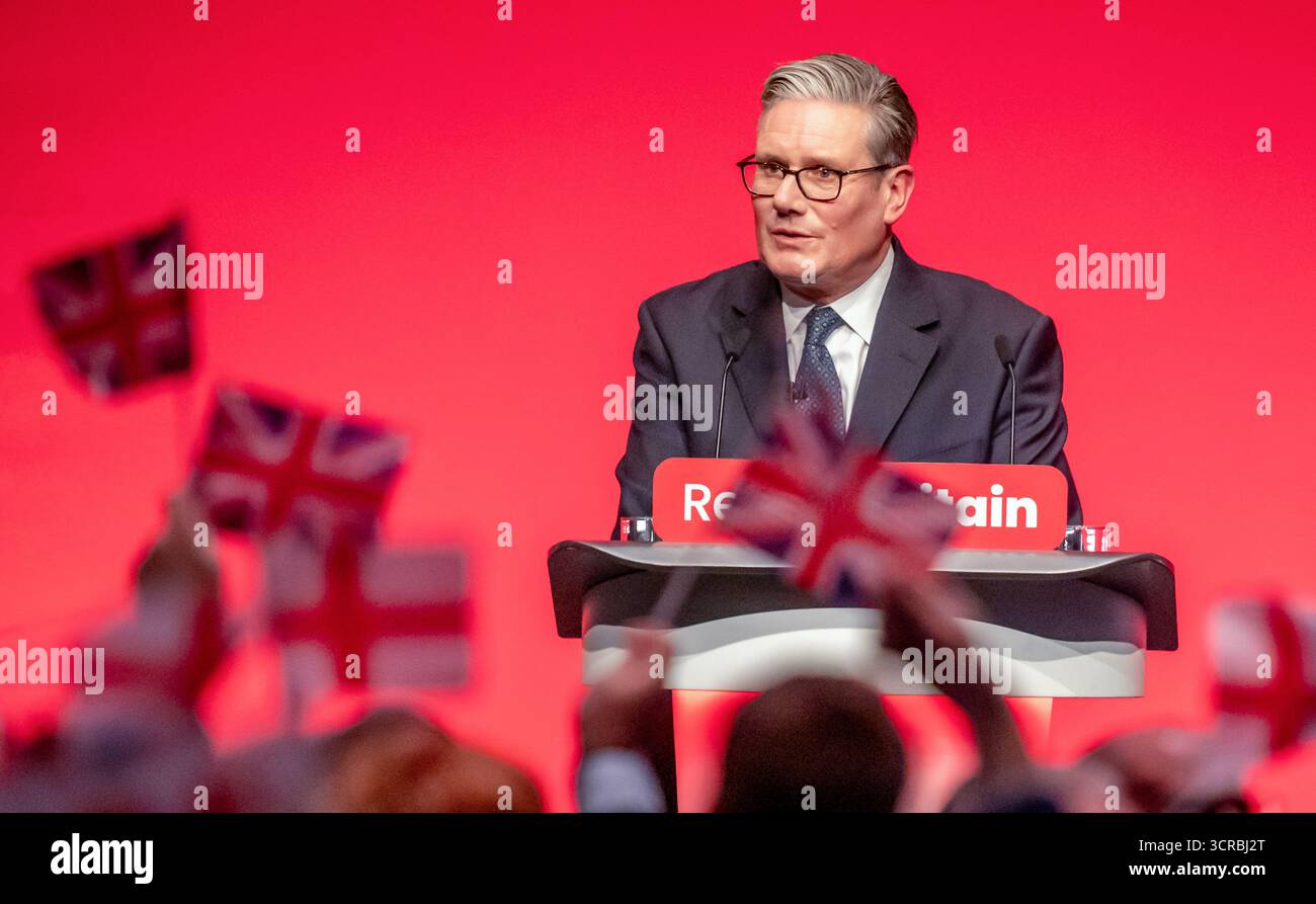 People wave flags as Prime Minister Sir Keir Starmer delivers his ...