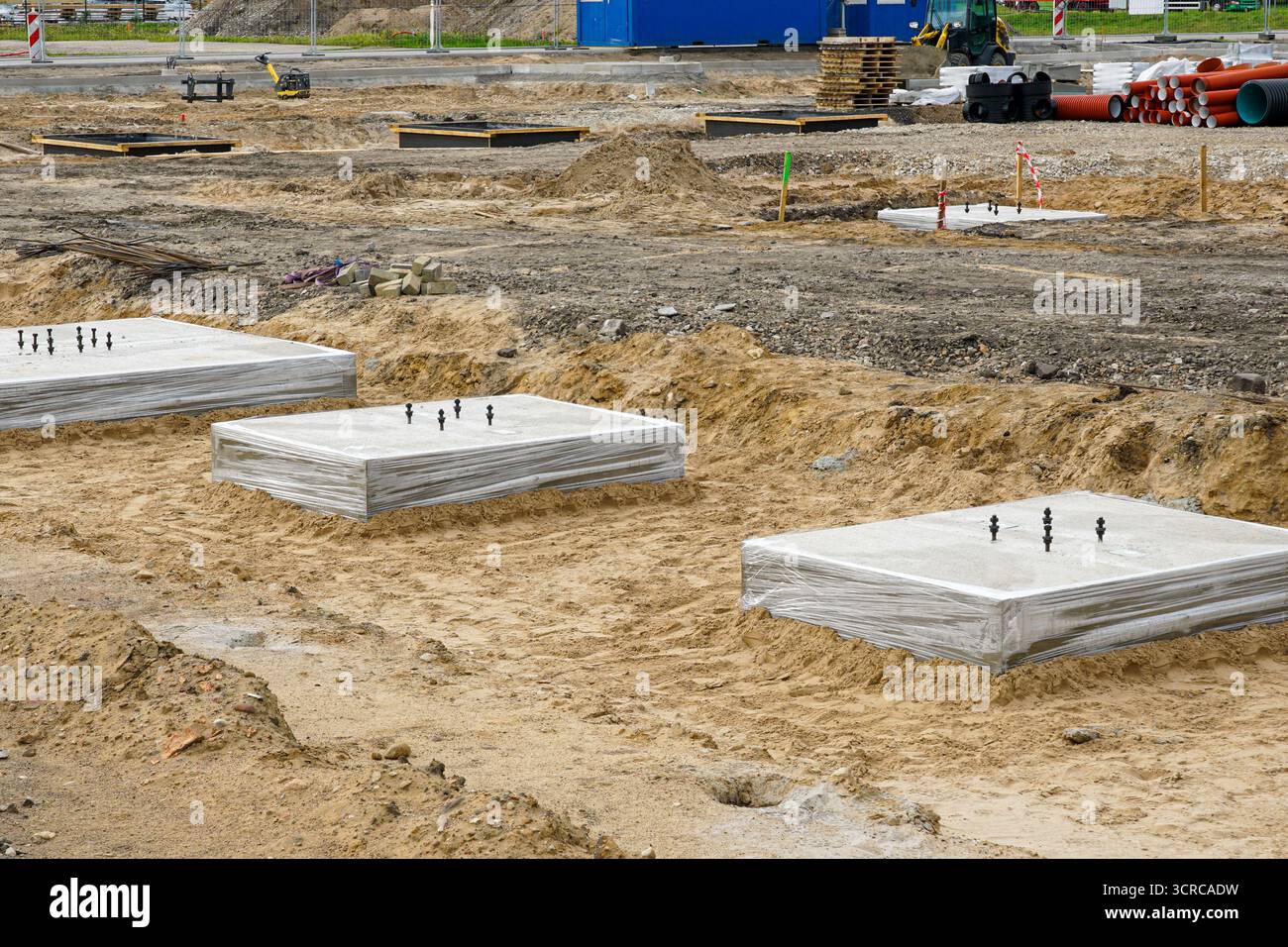 Concrete foundation blocks with anchor bolts installed in sandy soil at ...