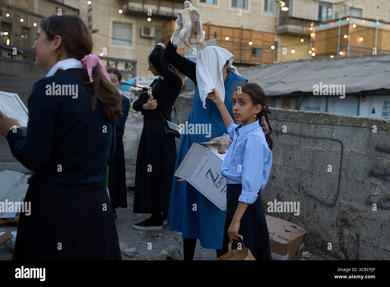 An ultra-Orthodox Jewish woman swings a chicken over her head in ...