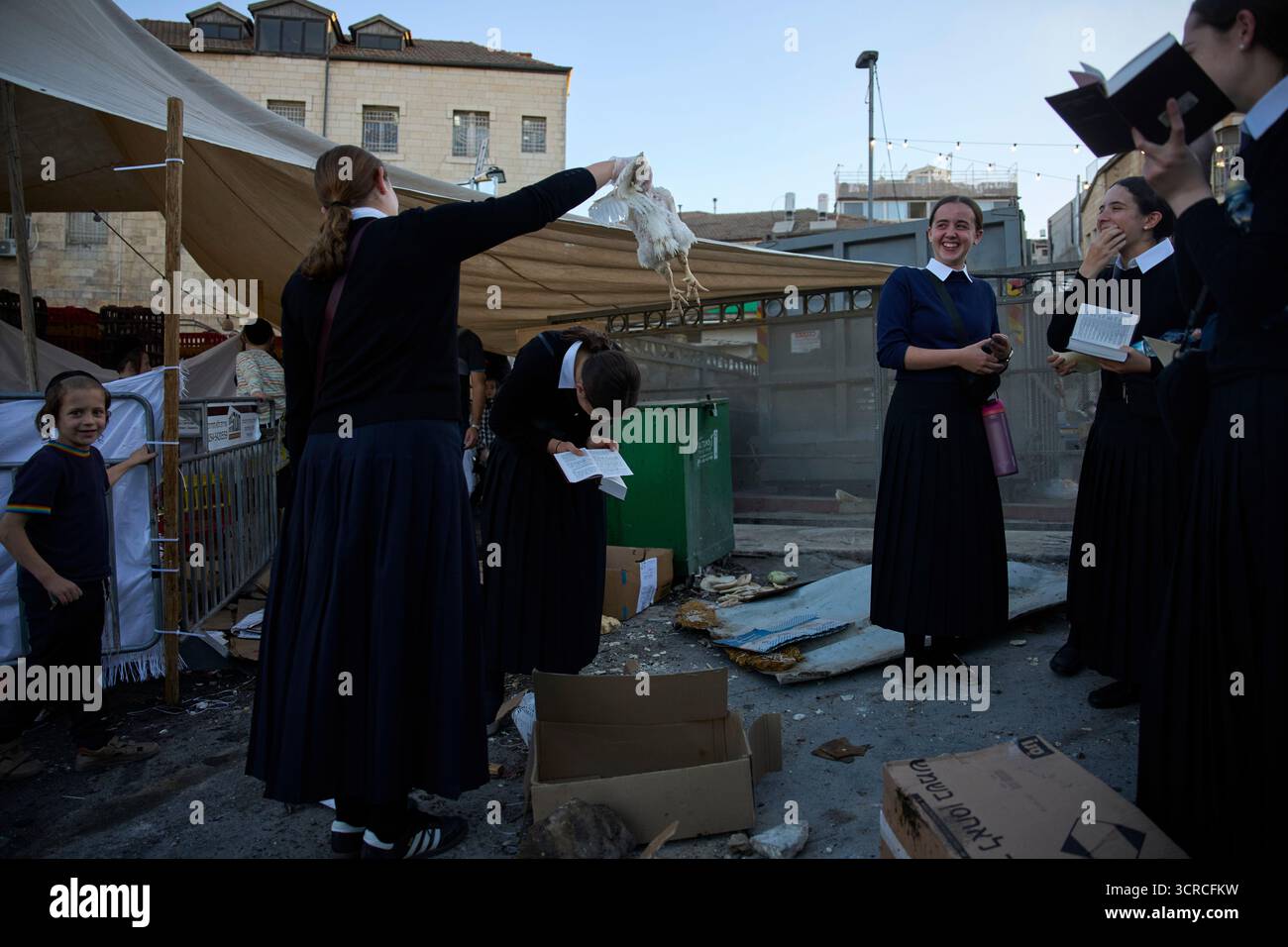 An ultra-Orthodox Jewish woman swings a chicken Over her friend's head ...