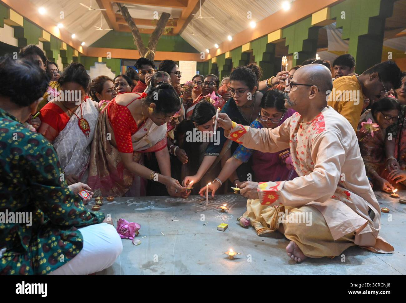 NOIDA, INDIA - SEPTEMBER 30: Devotees light earthen lamps Diyas while ...