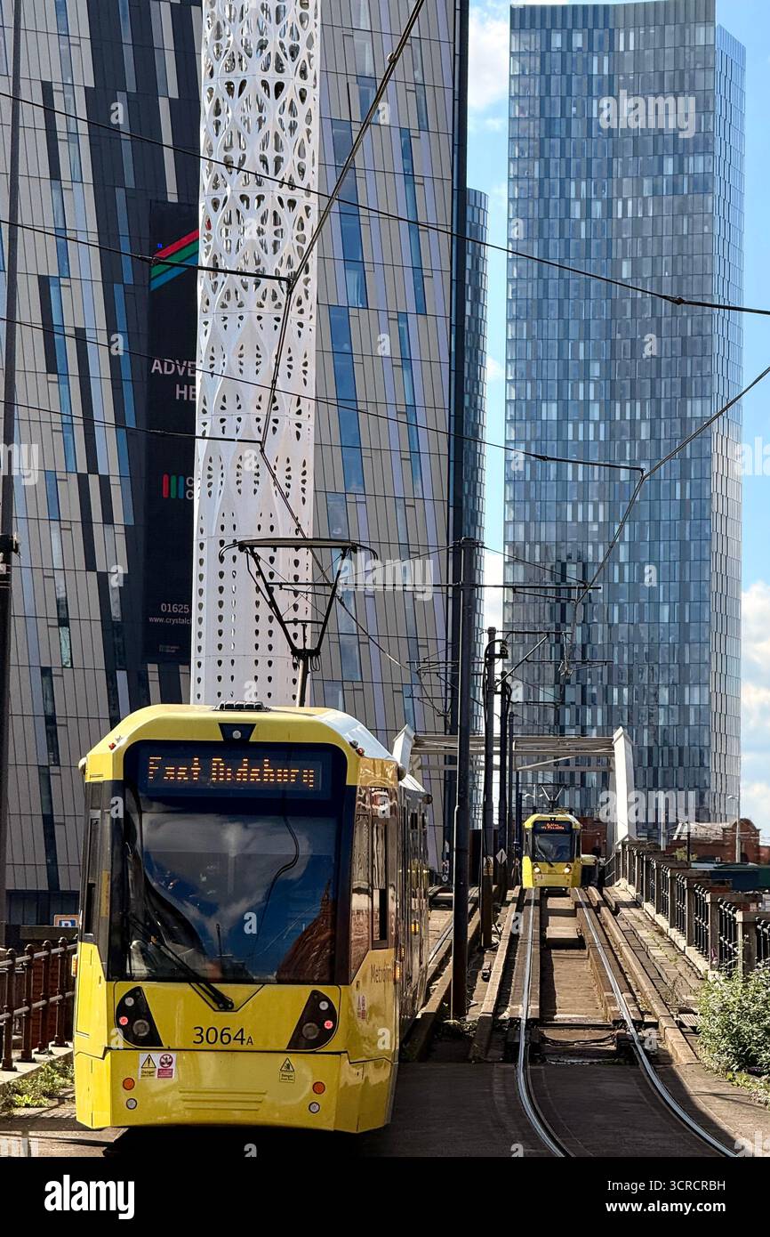 Manchester yellow trams with towers of Deansgate Square complex Square ...