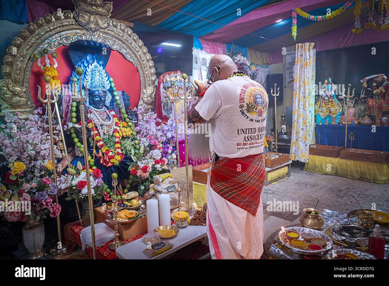 A devout Hindu priest bows his head in prayer & meditation in front of ...