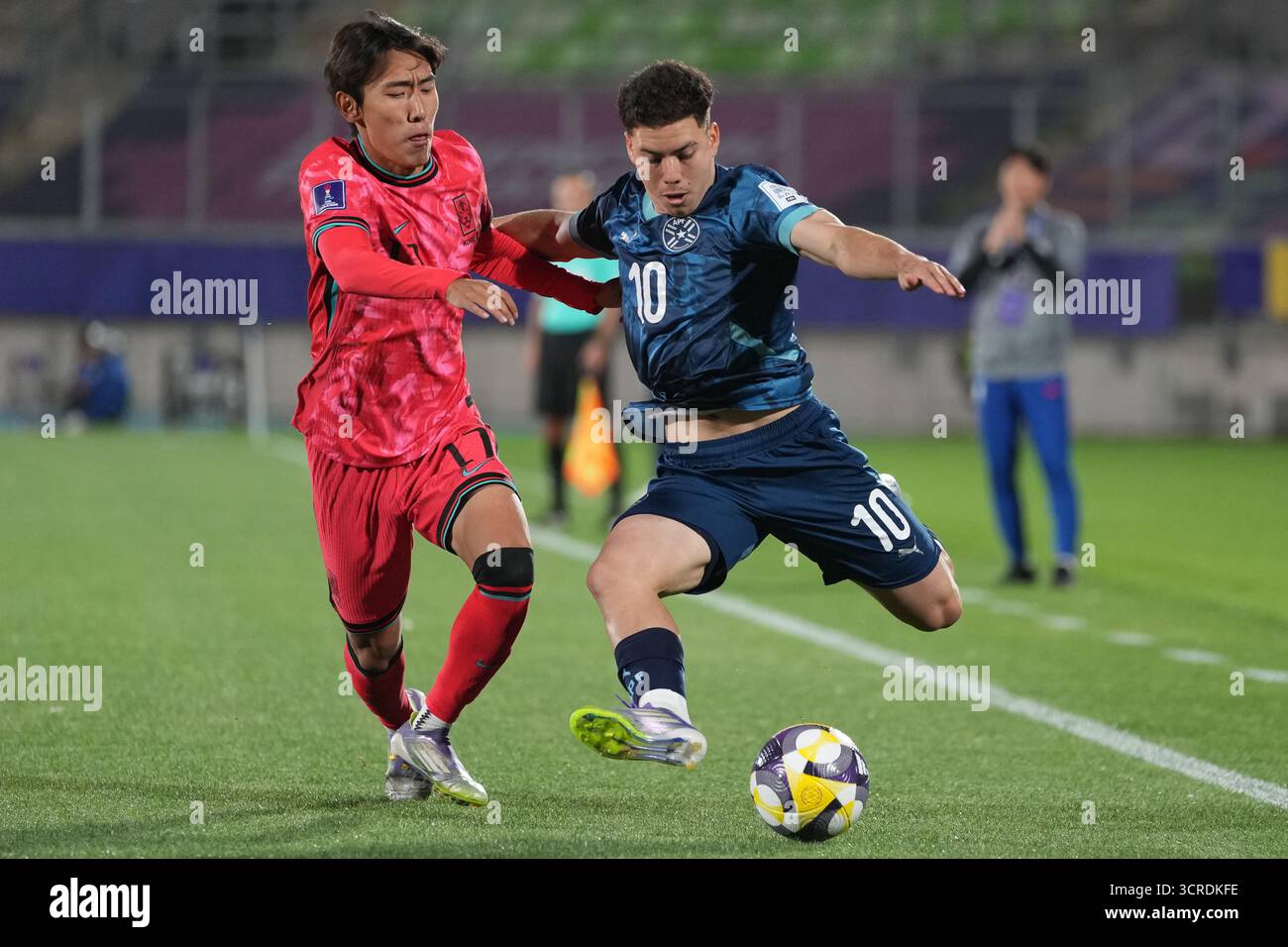 South Korea's Kim Hyun-min, left, fights for the ball with Paraguay's ...