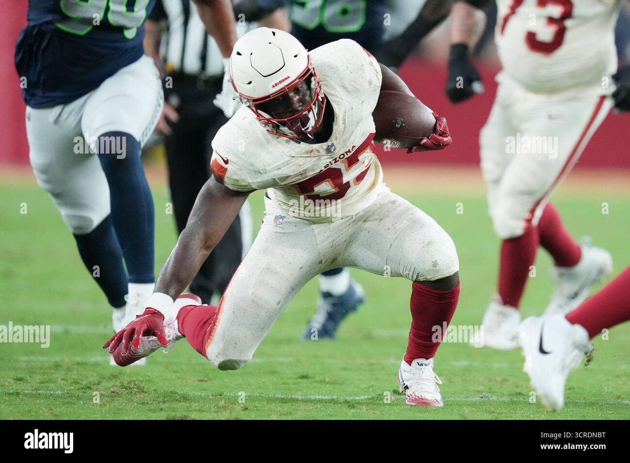 Arizona Cardinals running back Trey Benson gets tripped up against the ...