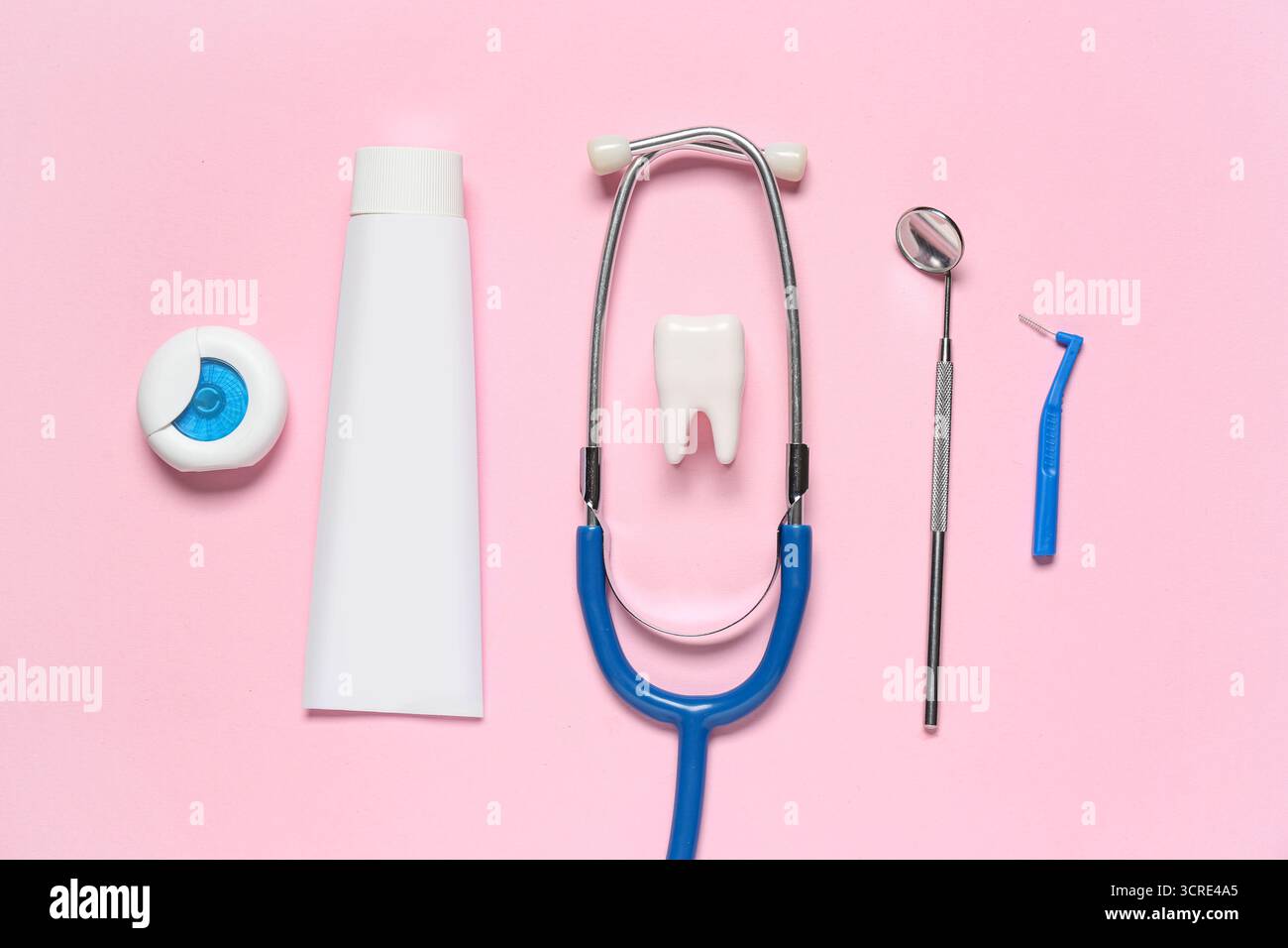 Decorative plastic tooth, toothpaste, stethoscope, dental mirror and ...