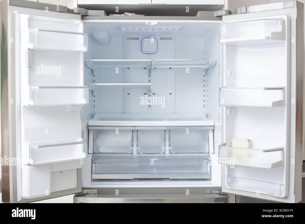 A view of a modern refrigerator unit with its doors wide open showing ...