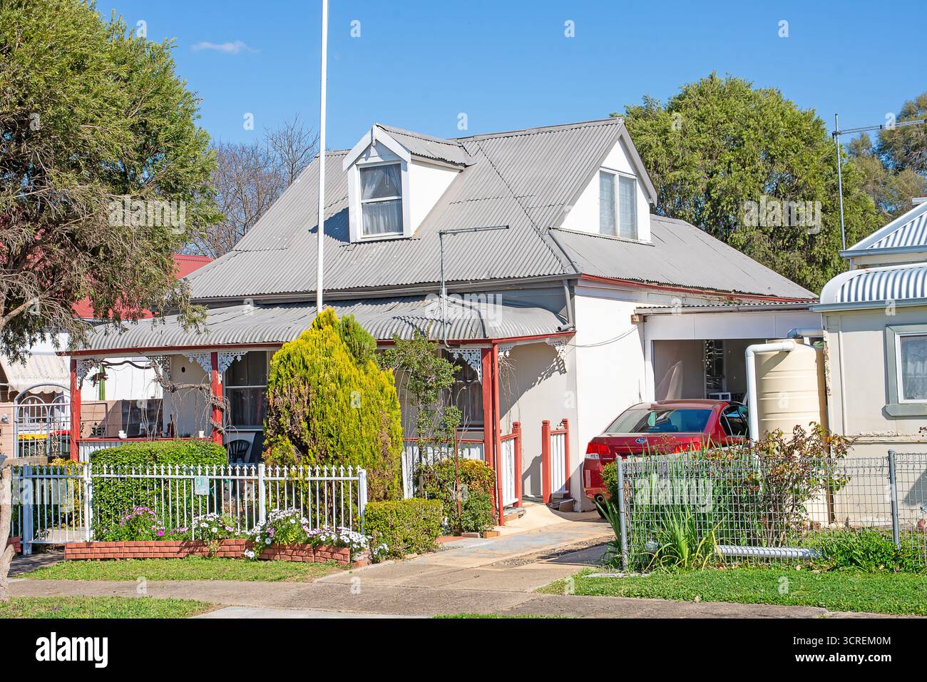 Small Cottage with Attic Extension and Bullnose Veranda behind a neat ...
