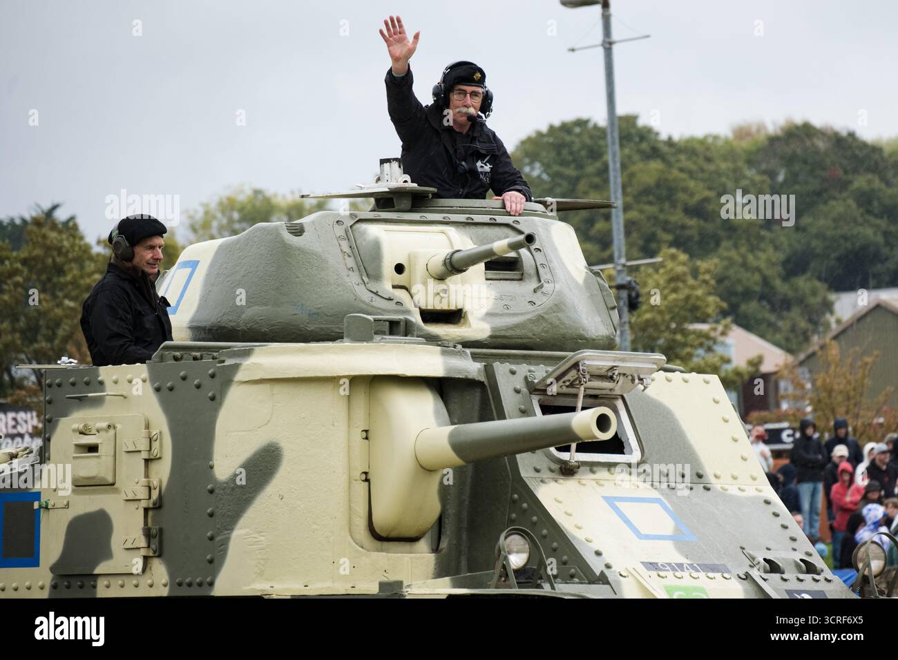 The tank crews in a M3 Grant tank wave at the spectators. The Tank ...