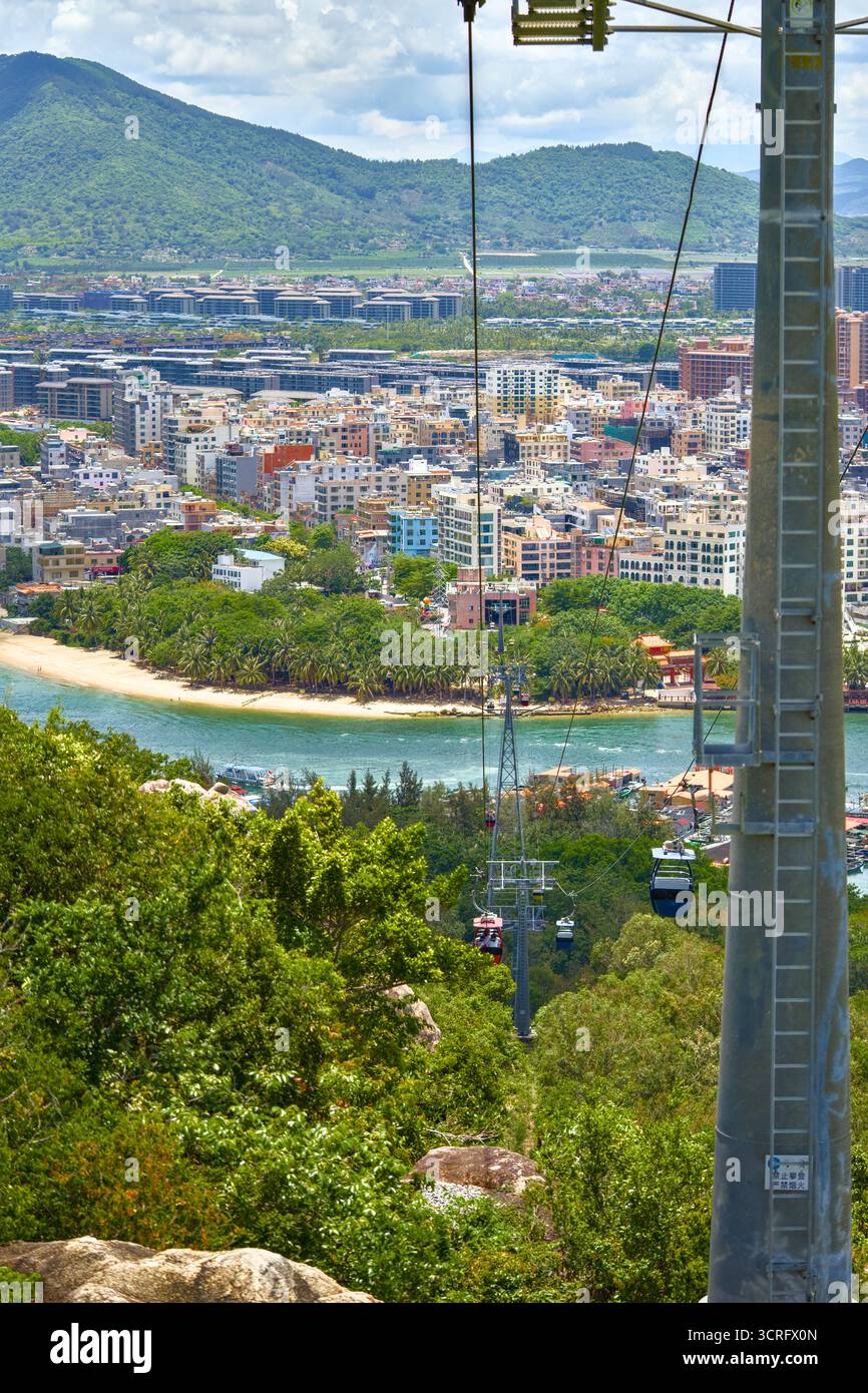 A scenic cable car is ascending a hill that overlooks a bustling city ...