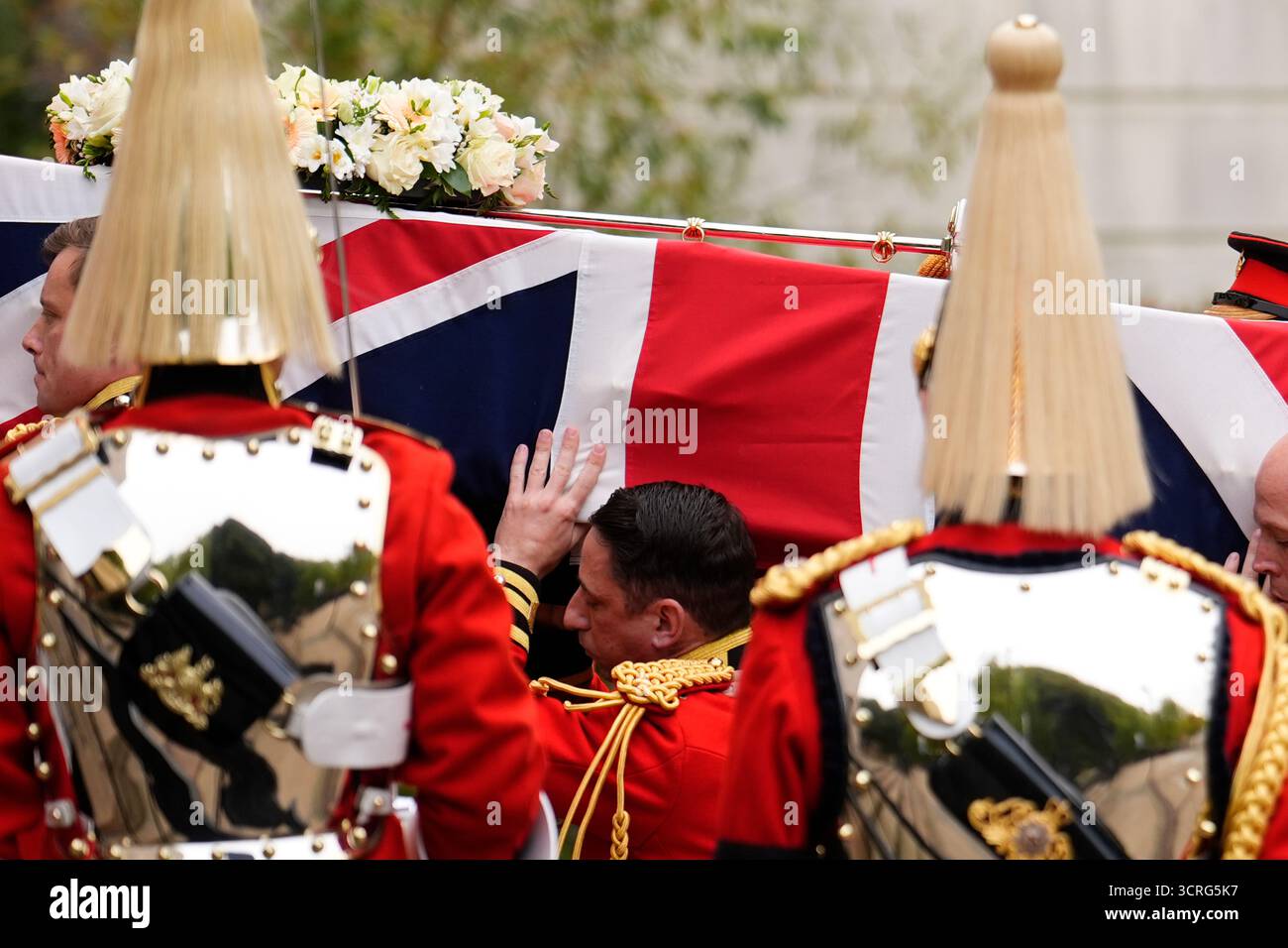 The Bearer Party carry the coffin past step liners from the Life Guards ...
