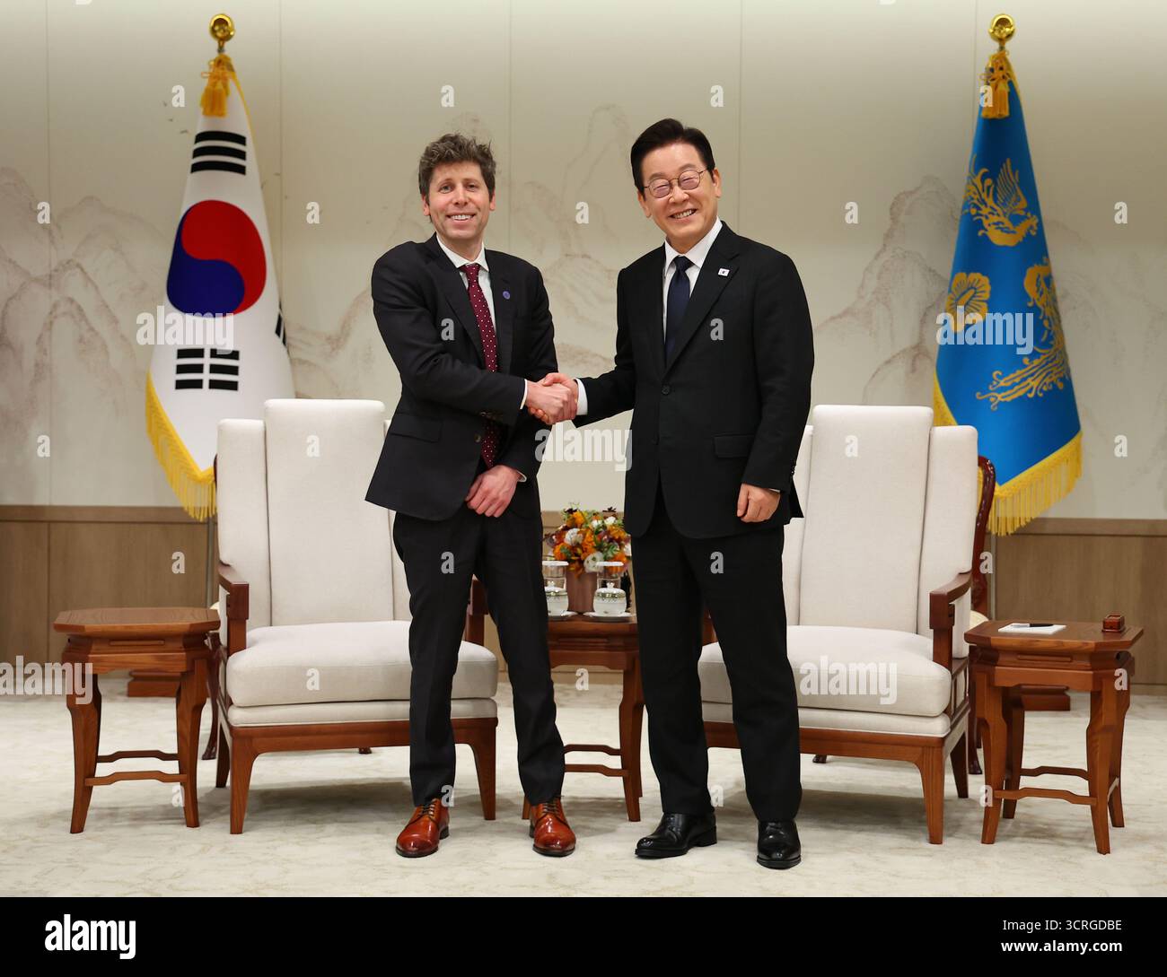 South Korean President Lee Jae Myung, right, shakes hands with OpenAI ...