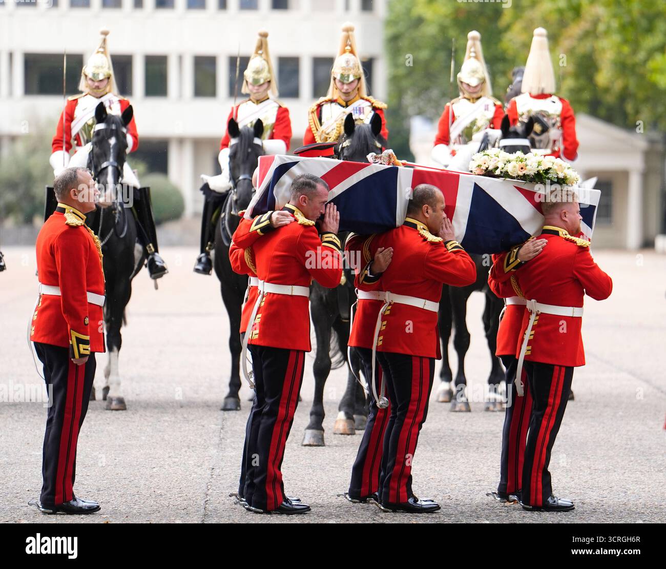 The Bearer Party carry the coffin past members of the Life Guards after ...