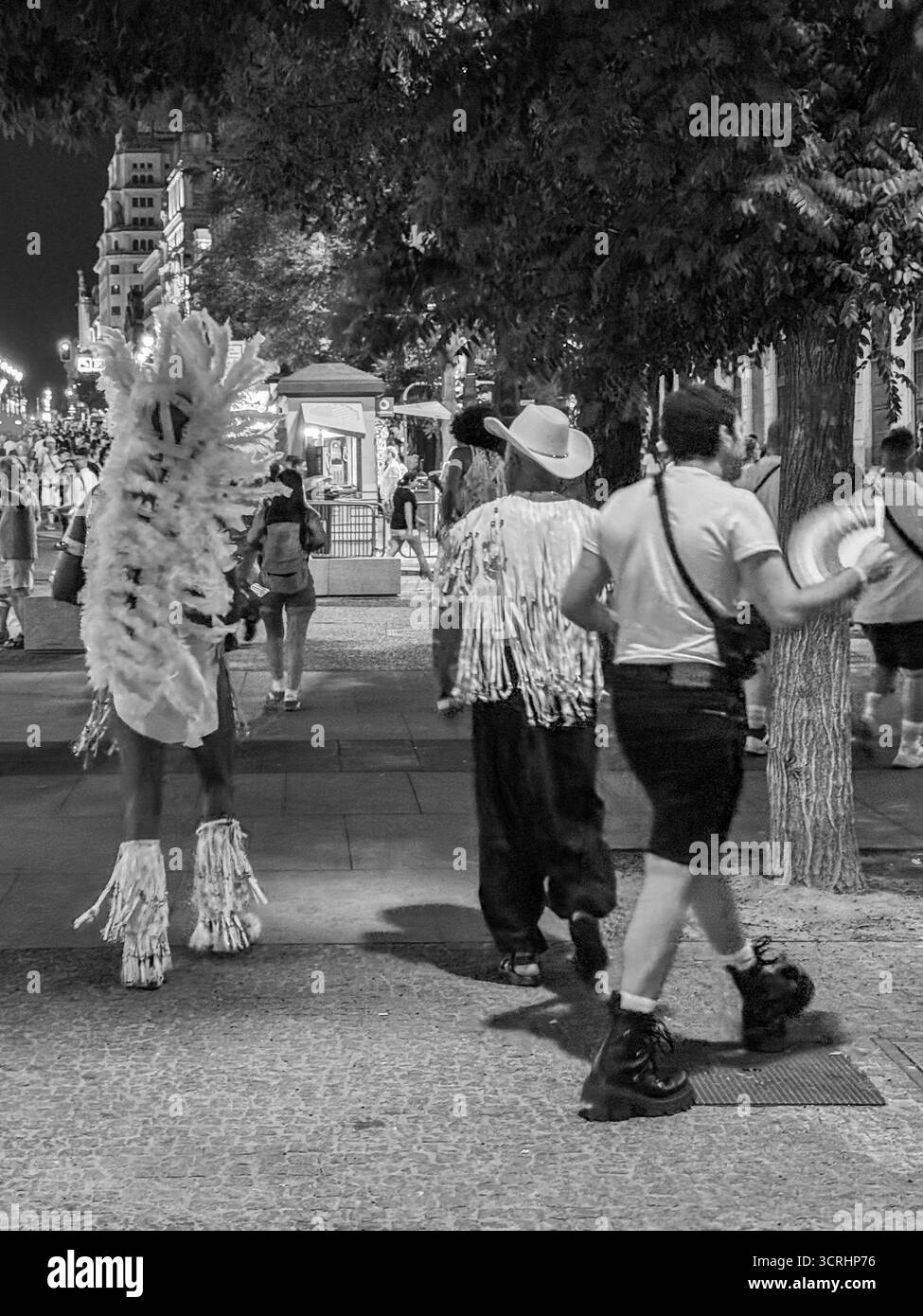 Group of people in festive and costume attire walking through a lively ...