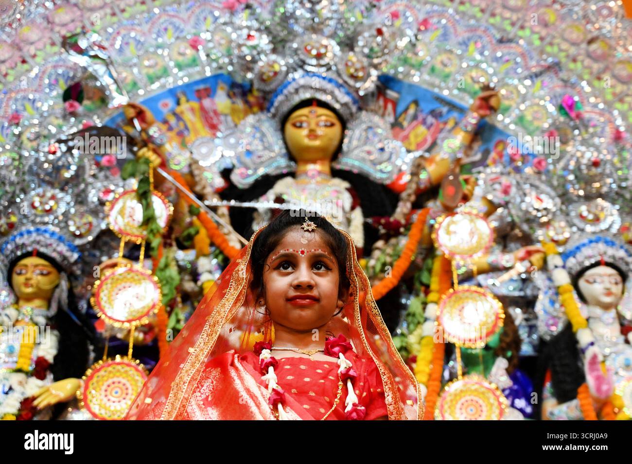 NOIDA, INDIA - OCTOBER 1: Young girl stands in front of Goddess Durga idol as Kumari Puja is ...