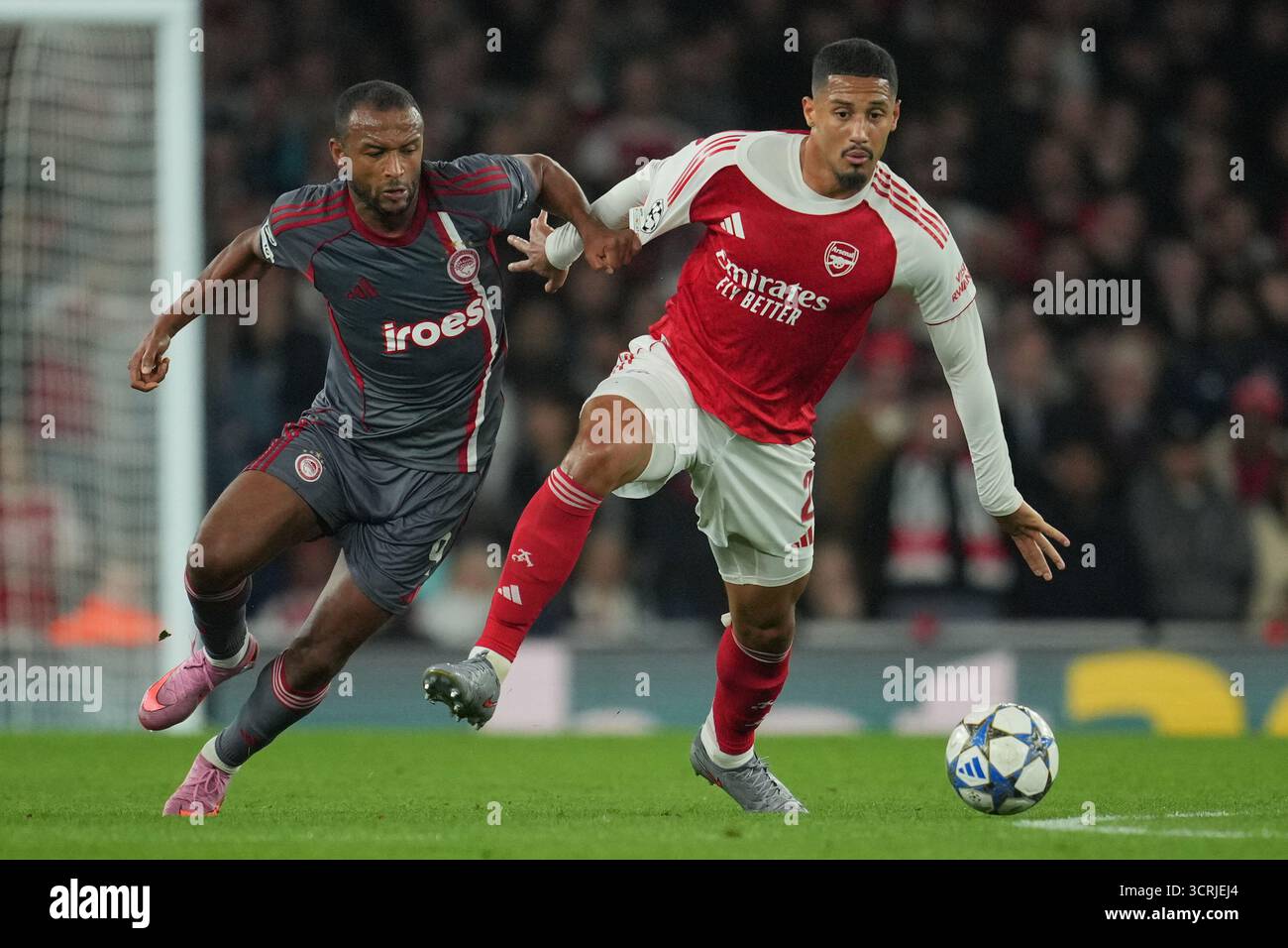 Olympiacos' Ayoub El Kaabi, left, challenges Arsenal's William Saliba ...