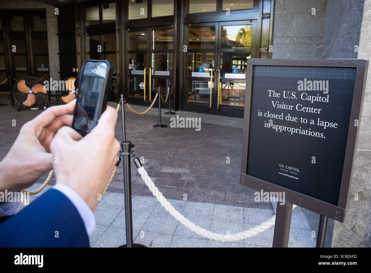 A reporter takes a photo of a sign that says "The U.S. Capitol Visitor ...