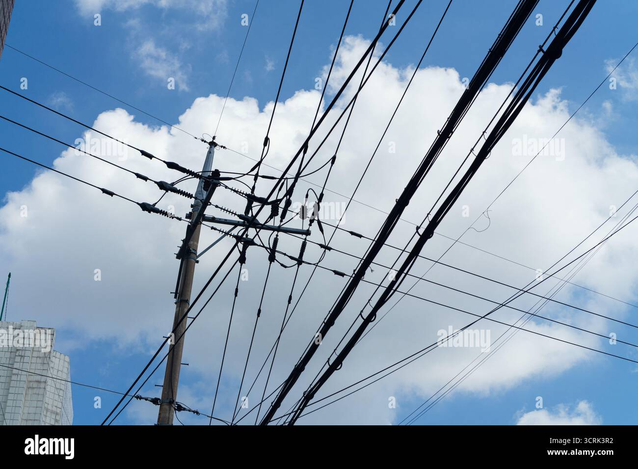 Messy and tangled electrical power lines on a utility pole against a ...
