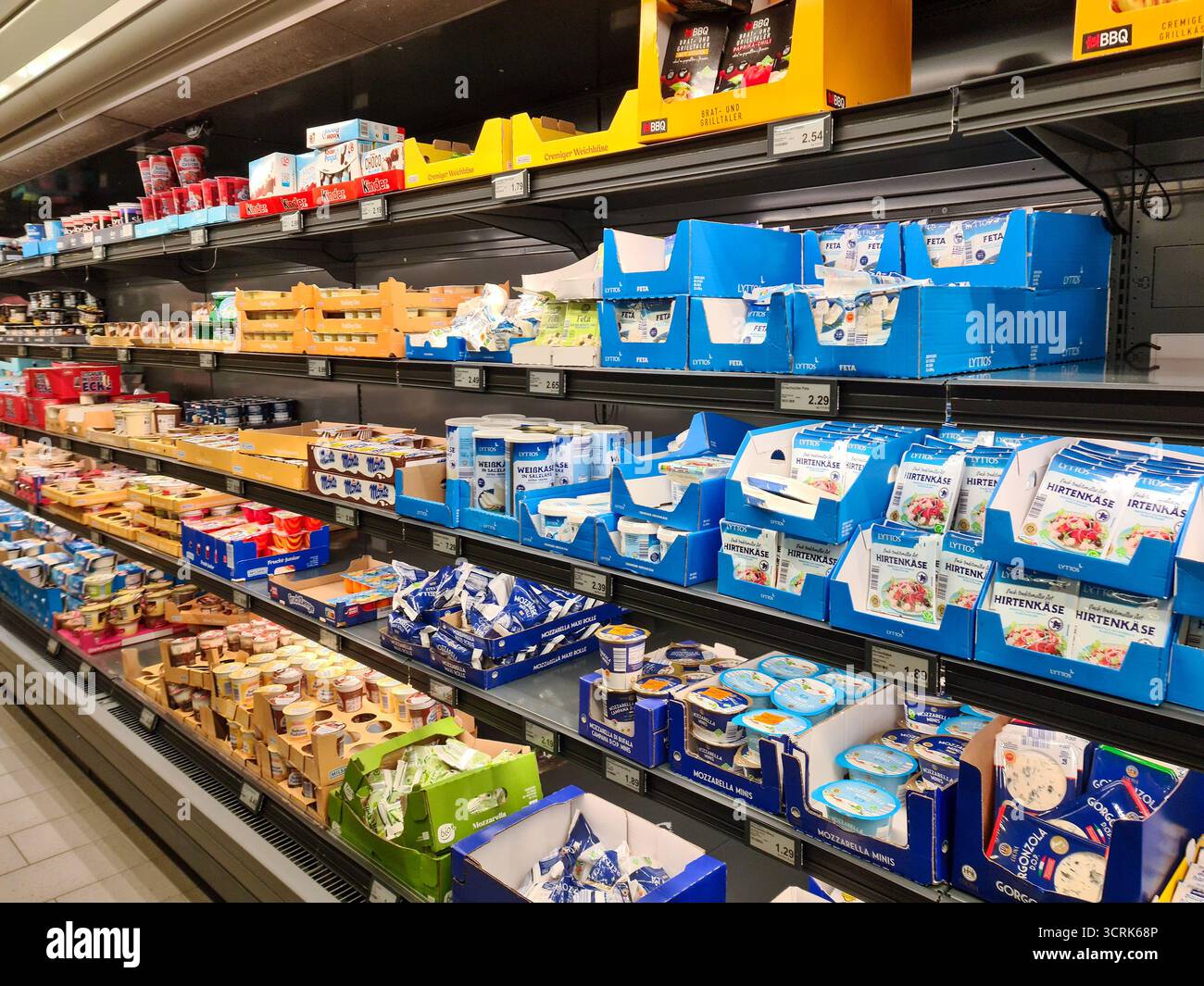Supermarket refrigerated aisle filling with various dairy and cheese ...