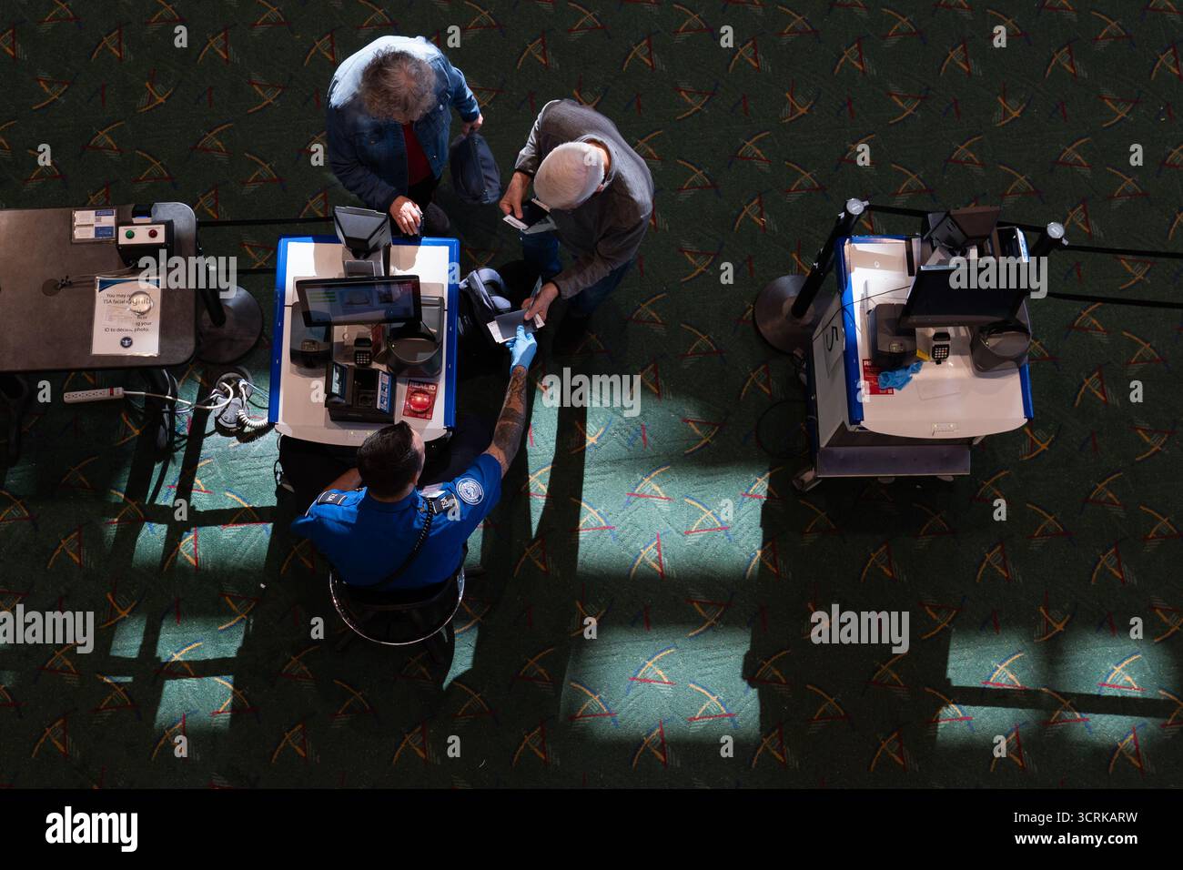 A Transportation Security Administration worker screens travelers at a ...