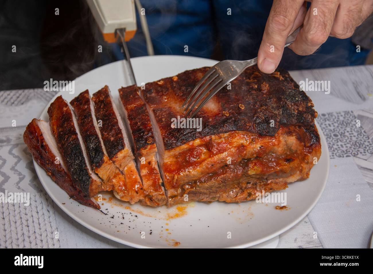 a person carving a roasted pork loin. A pork loin roast is a large cut ...