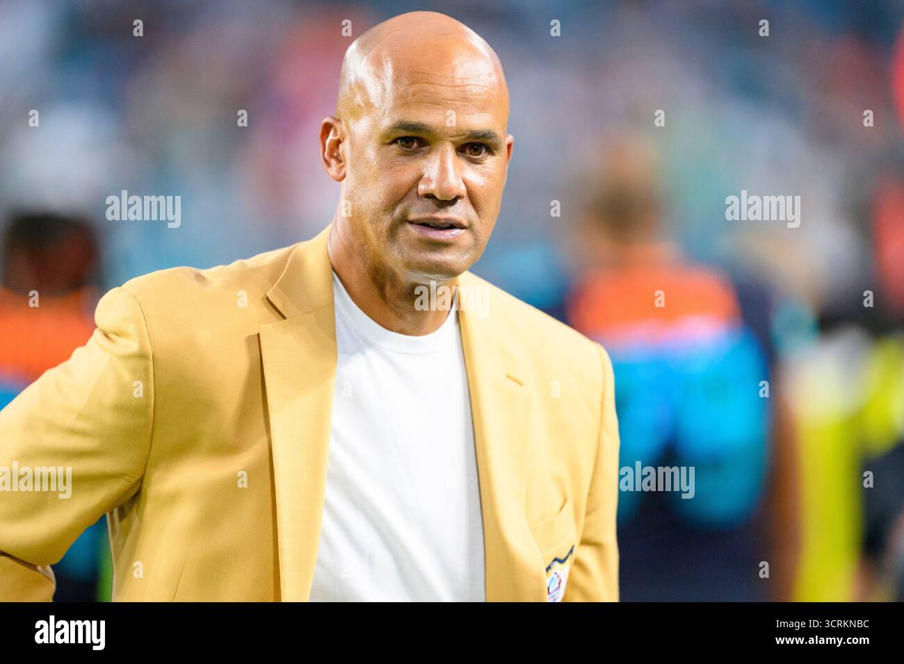 Former Miami Dolphins player Jason Taylor walks on the sidelines before an NFL football game ...