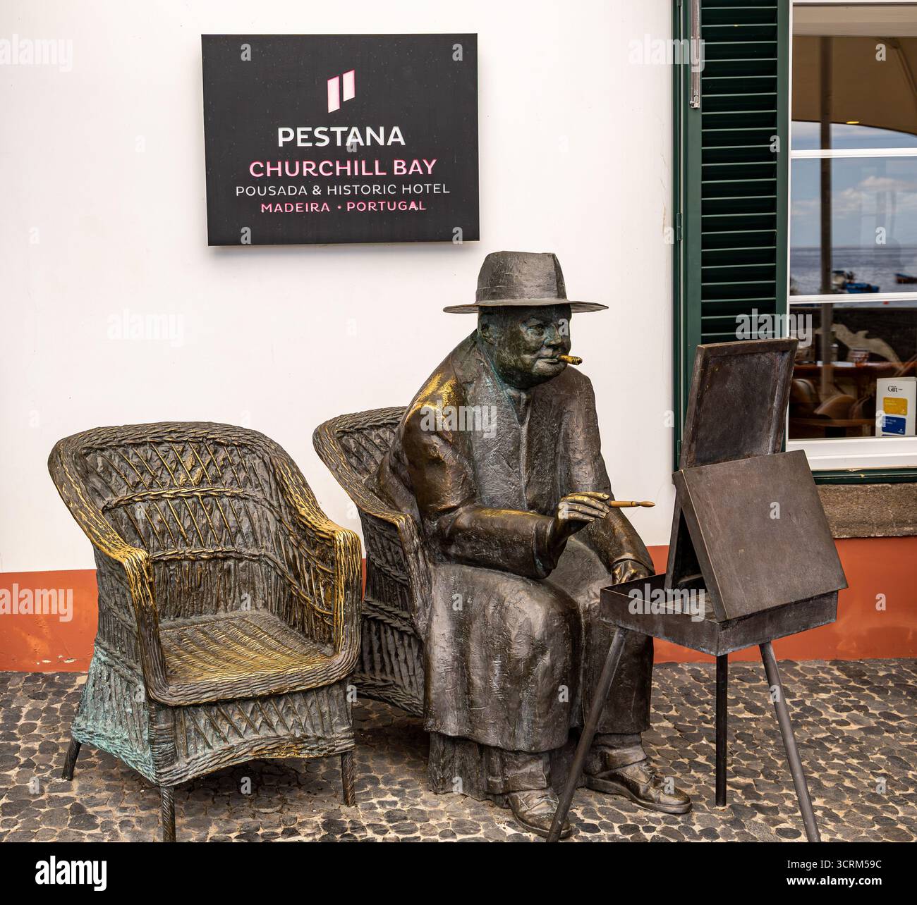 Bronze statue of Sir Winston Churchill sitting with an easel and chair ...