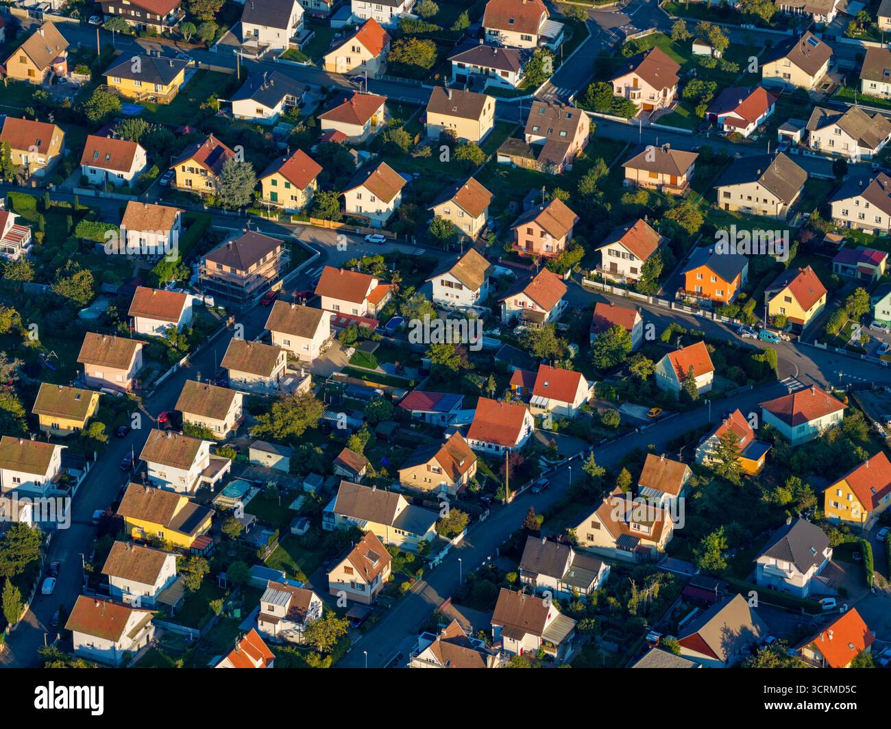 Aerial view of a dense suburban sprawl with red-tiled roofs contrasting ...