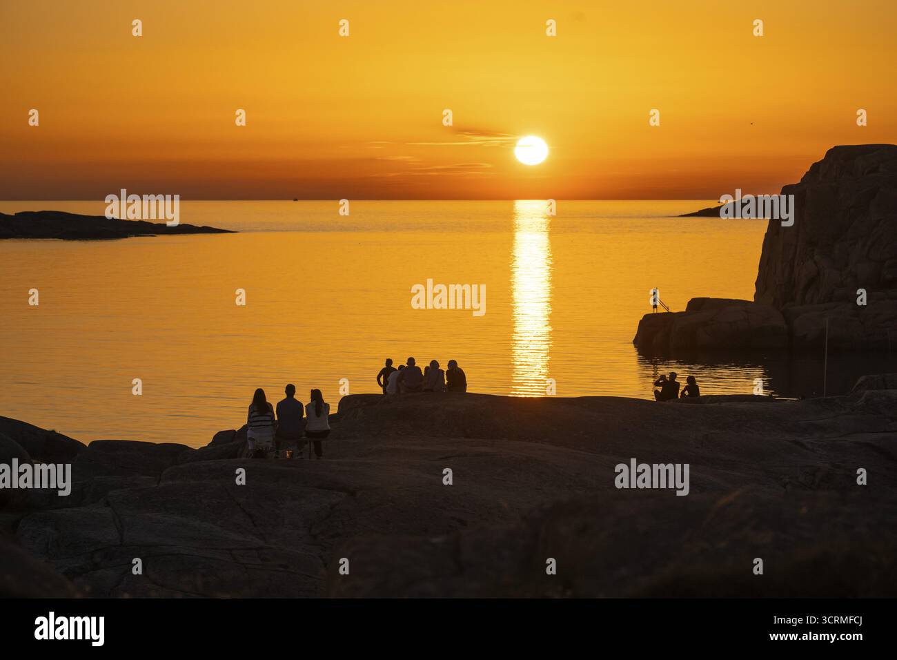 Silhouettes of tourists, sun melting in the sea, sunset, archipelago ...
