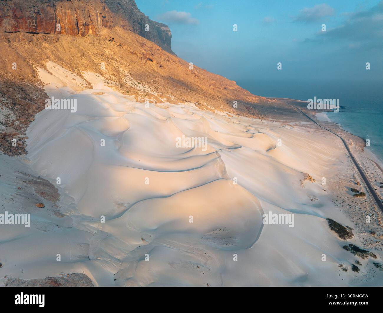 Aerial view of sprawling white sand dunes contrast against rugged ...