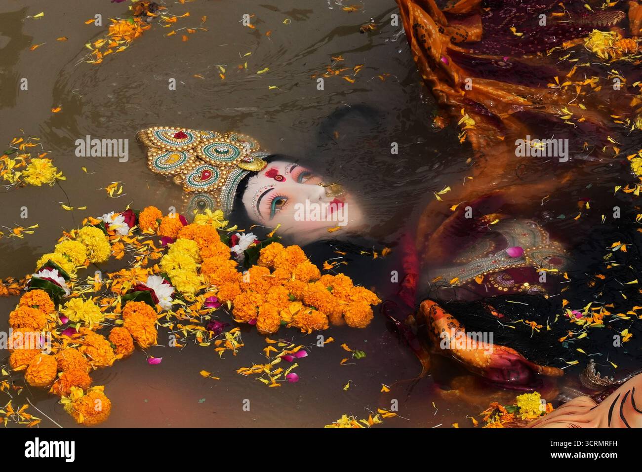 Devotees immerse an idol of Hindu goddess Durga in a makeshift water ...